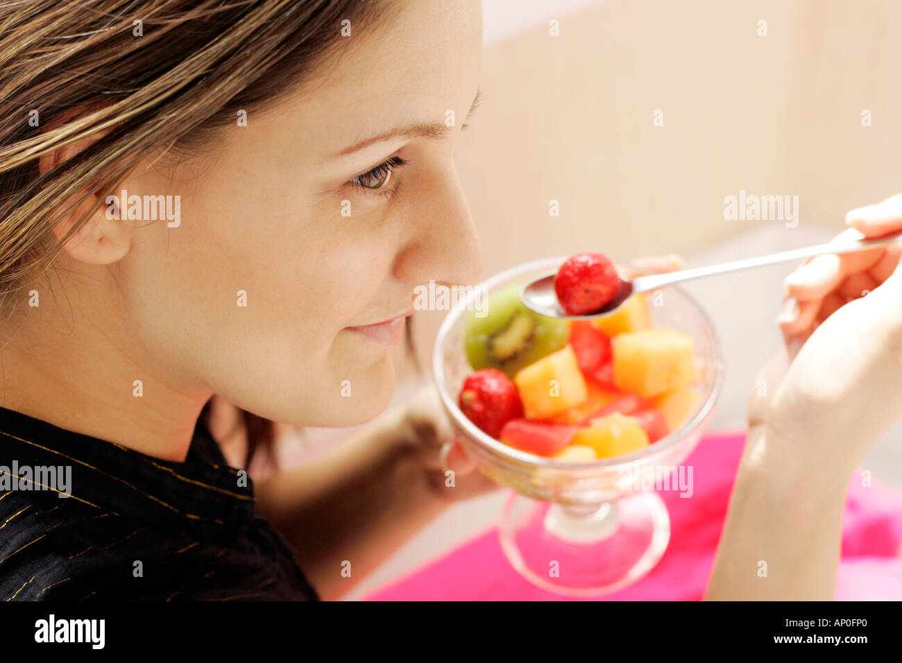 Woman eating fresh fruit salad Stock Photo - Alamy
