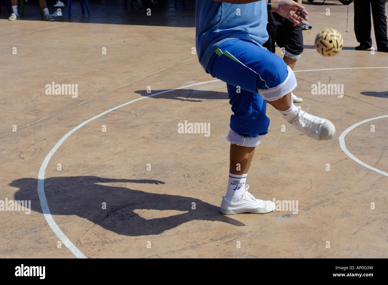 A player in a Sepak Raga game trying to keep a rattan ball in the air ...