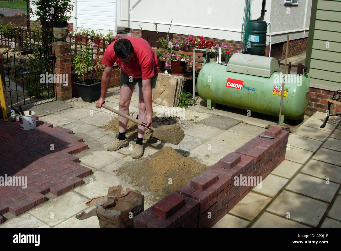 An adult male mixing cement by hand at a building site Stock Photo - Alamy