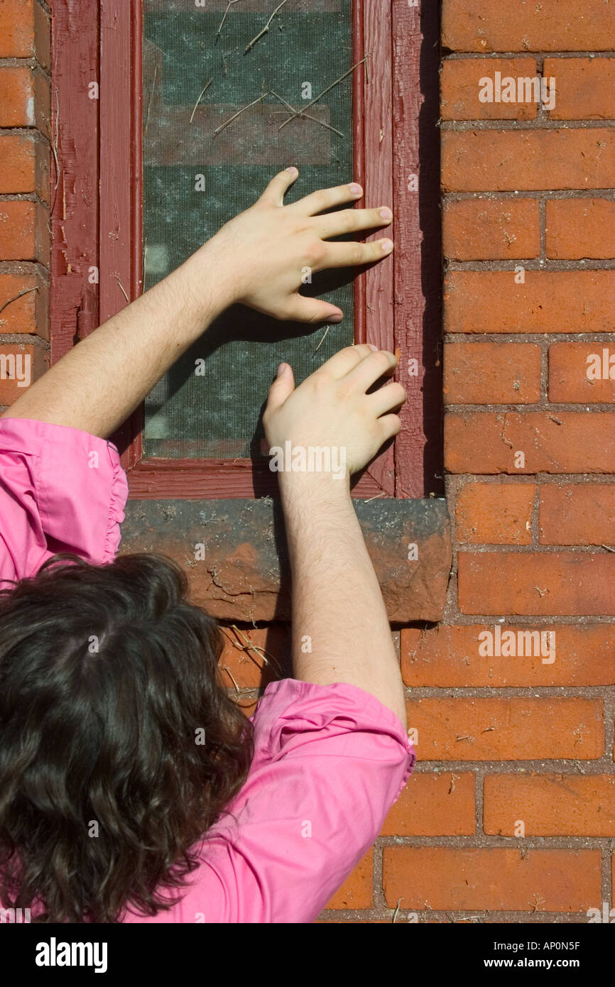 Teen boy trying to open a building s outside window Model Released ...