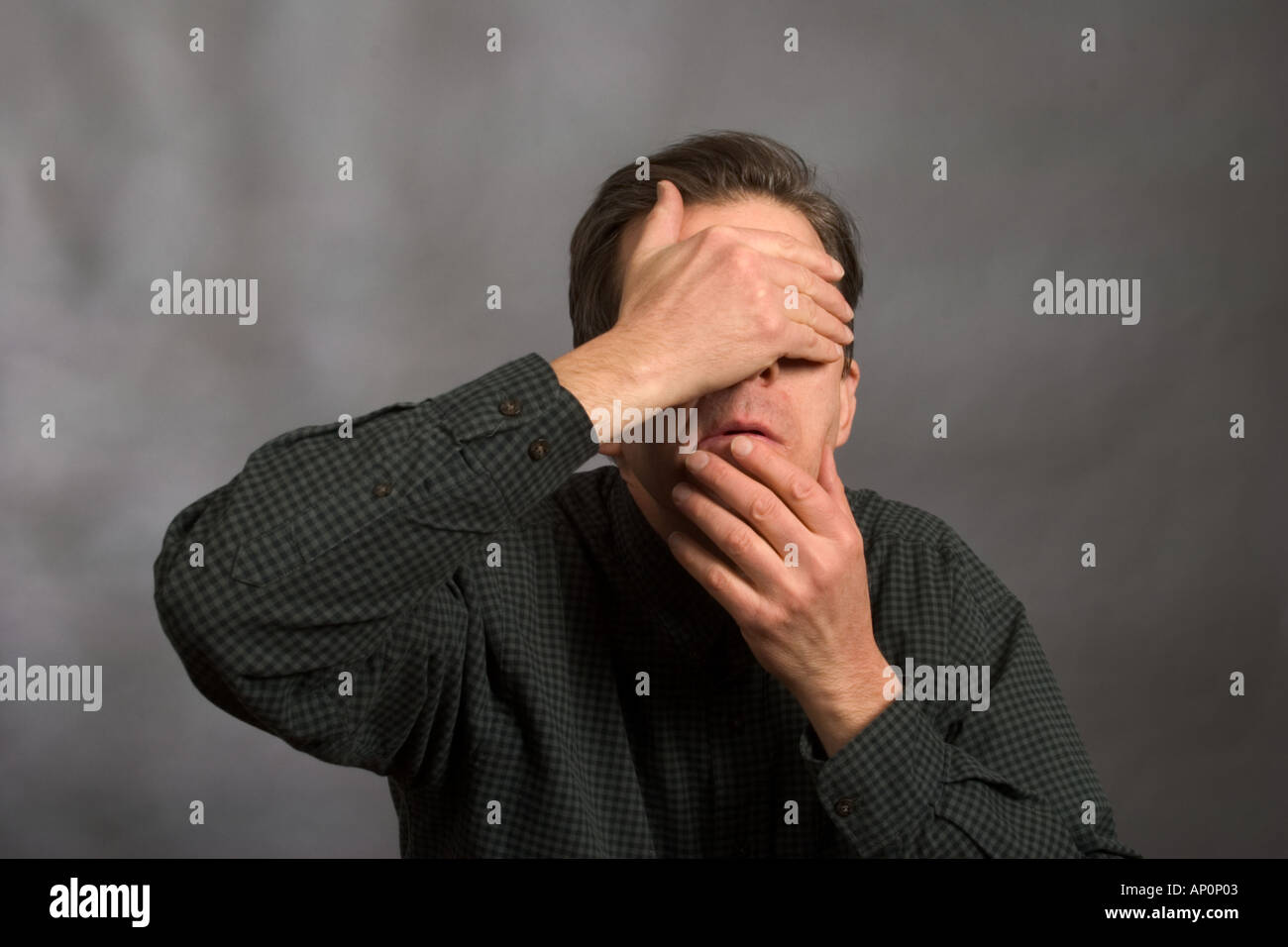 Man with one hand covering his eyes and the other one resting on his ...