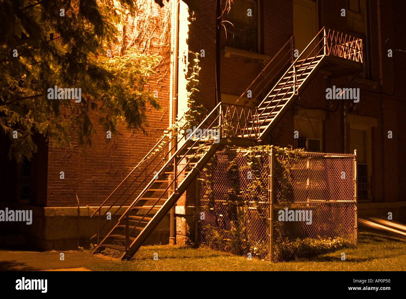 Bright light illuminating the staircase on the back of a brick building ...