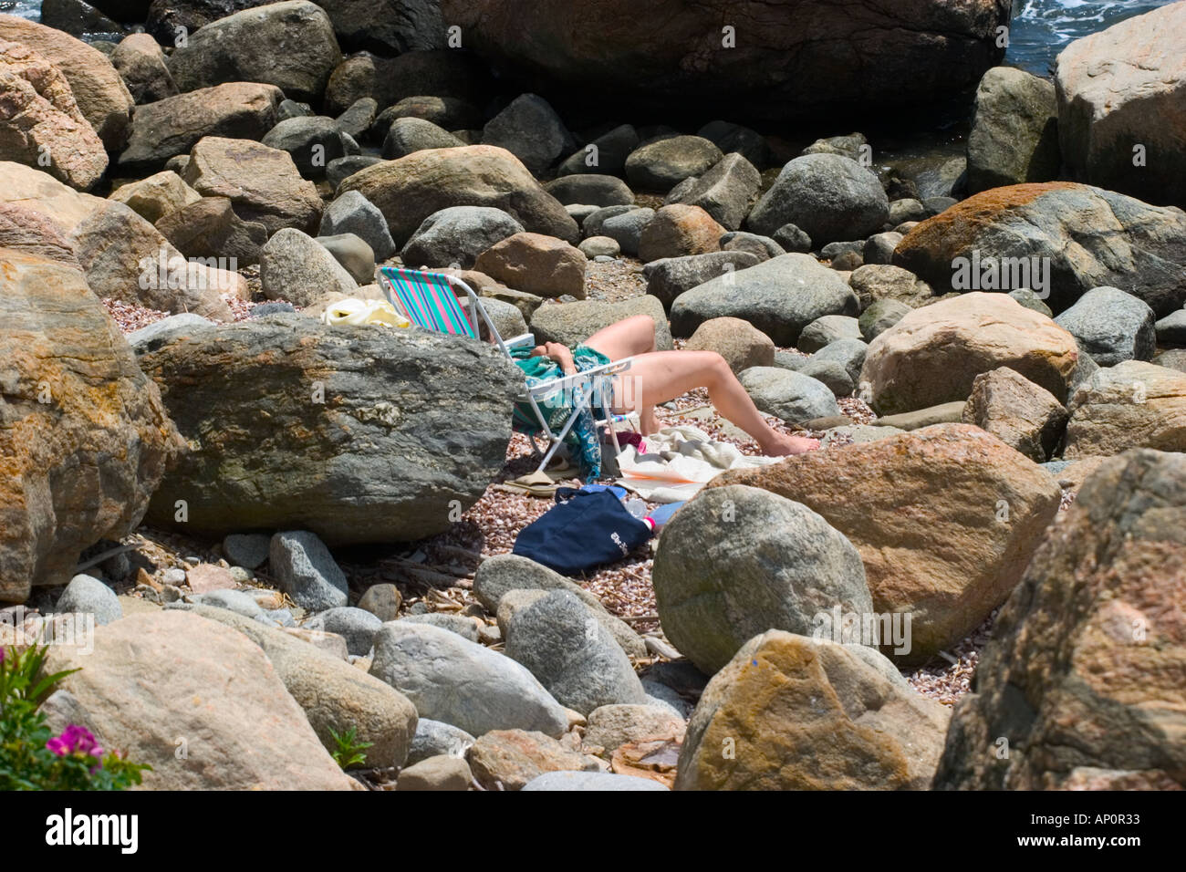 Woman at the beach in Connecticut USA sitting in seclusion in a folding ...