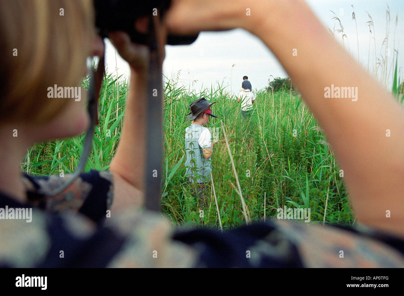 Family walking across reed, Dabitz near Barth, Fischland-Darss-Zingst ...
