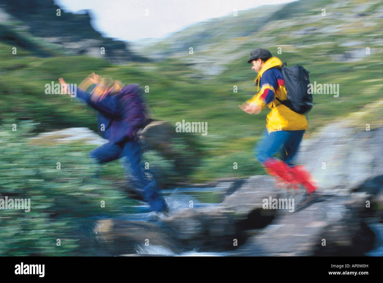 A couple on a hiking tour, jumping over rocks, Dumdalen im Jotunheimen ...