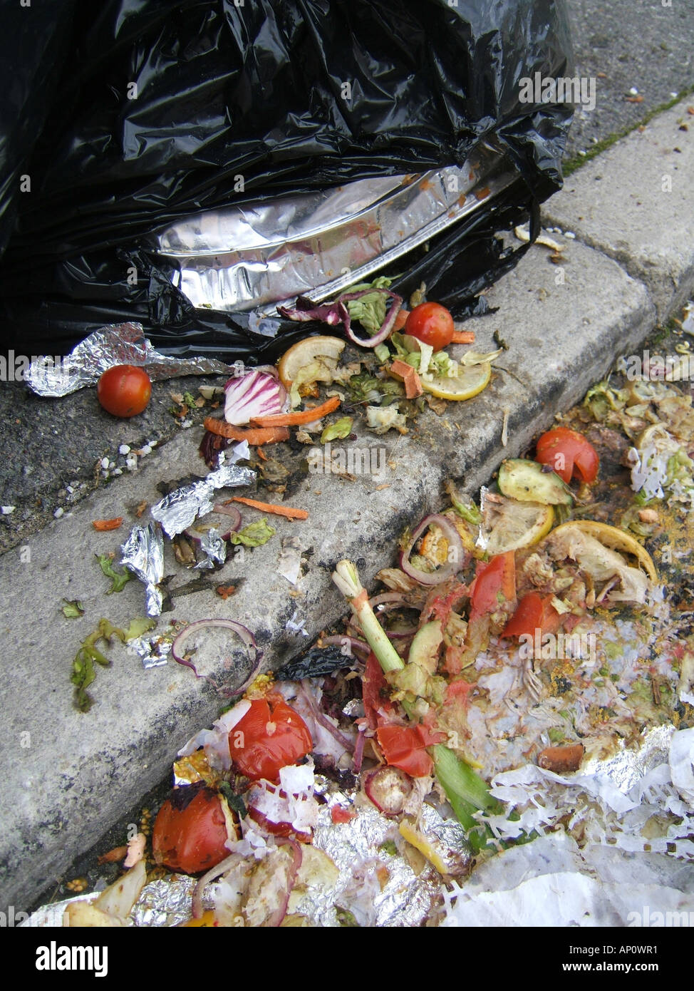 torn black refuse bag with waste food on pavement sidewalk Stock Photo ...