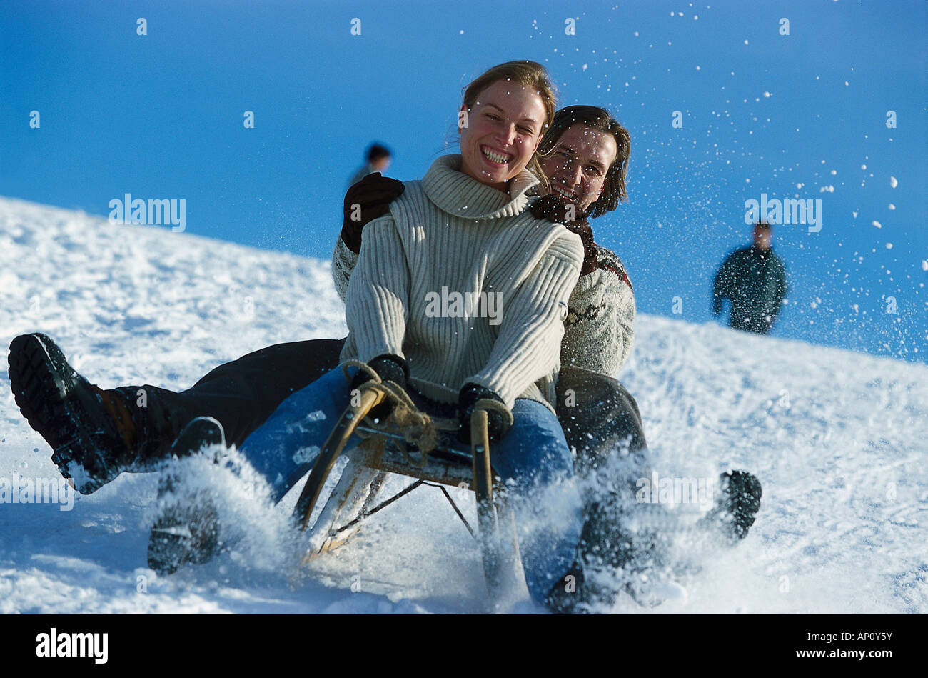 Young couple sledging down a slope, Winter sport Stock Photo - Alamy