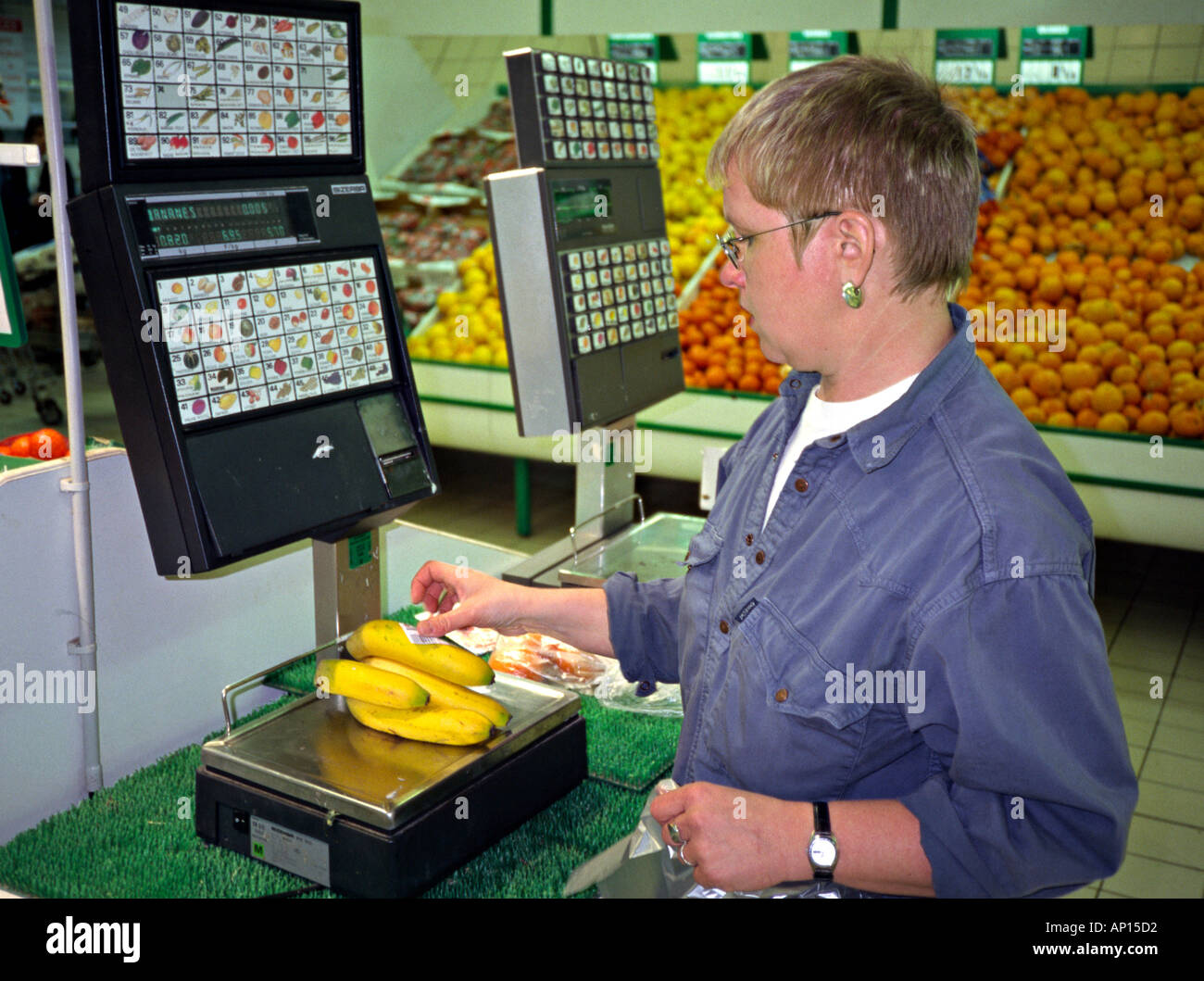 blonde woman measuring the weight of bananas to buy in a supermarket ...