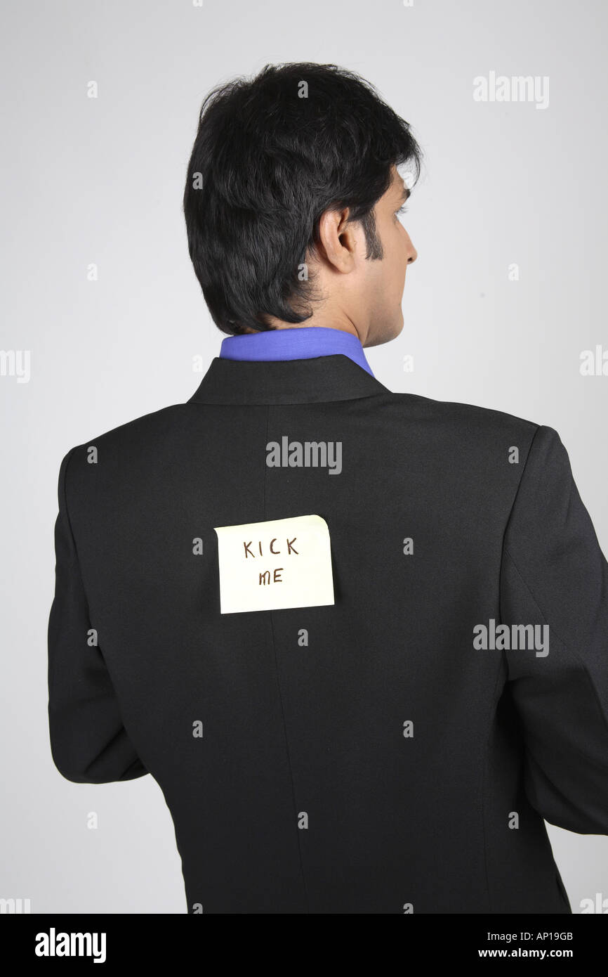 Kick me - Executive with the paper label sticker of kick me on his back ...