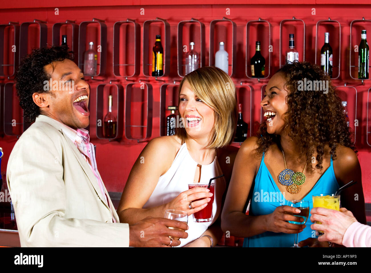 Three people having drinks in bar, laughing Stock Photo - Alamy