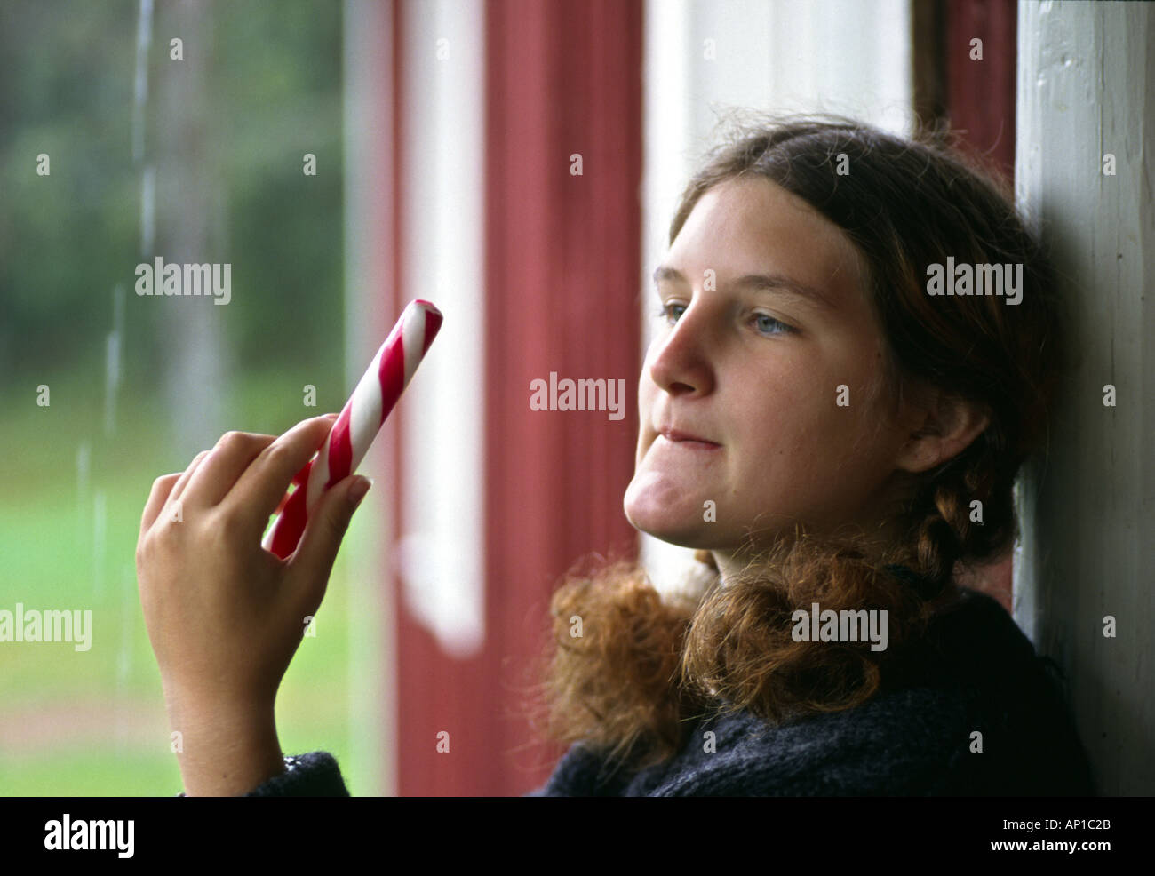 young girl is sucking on a candy bar Stock Photo - Alamy