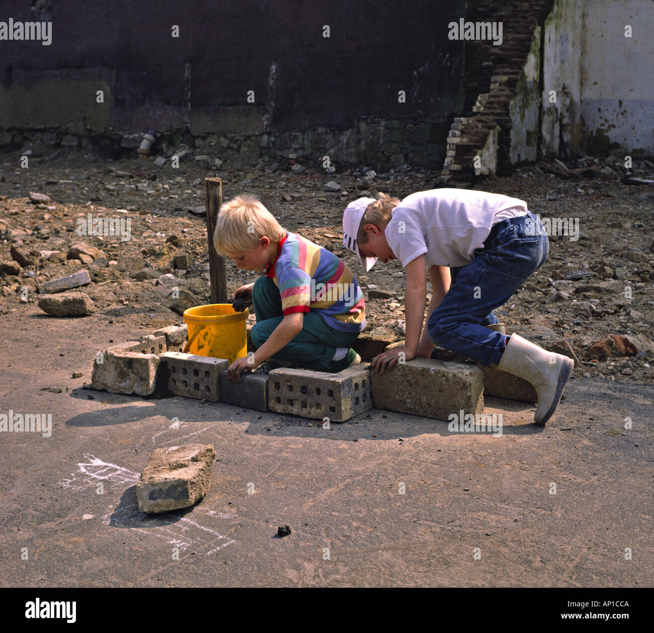 two boys playing with bricks on a building site Stock Photo - Alamy