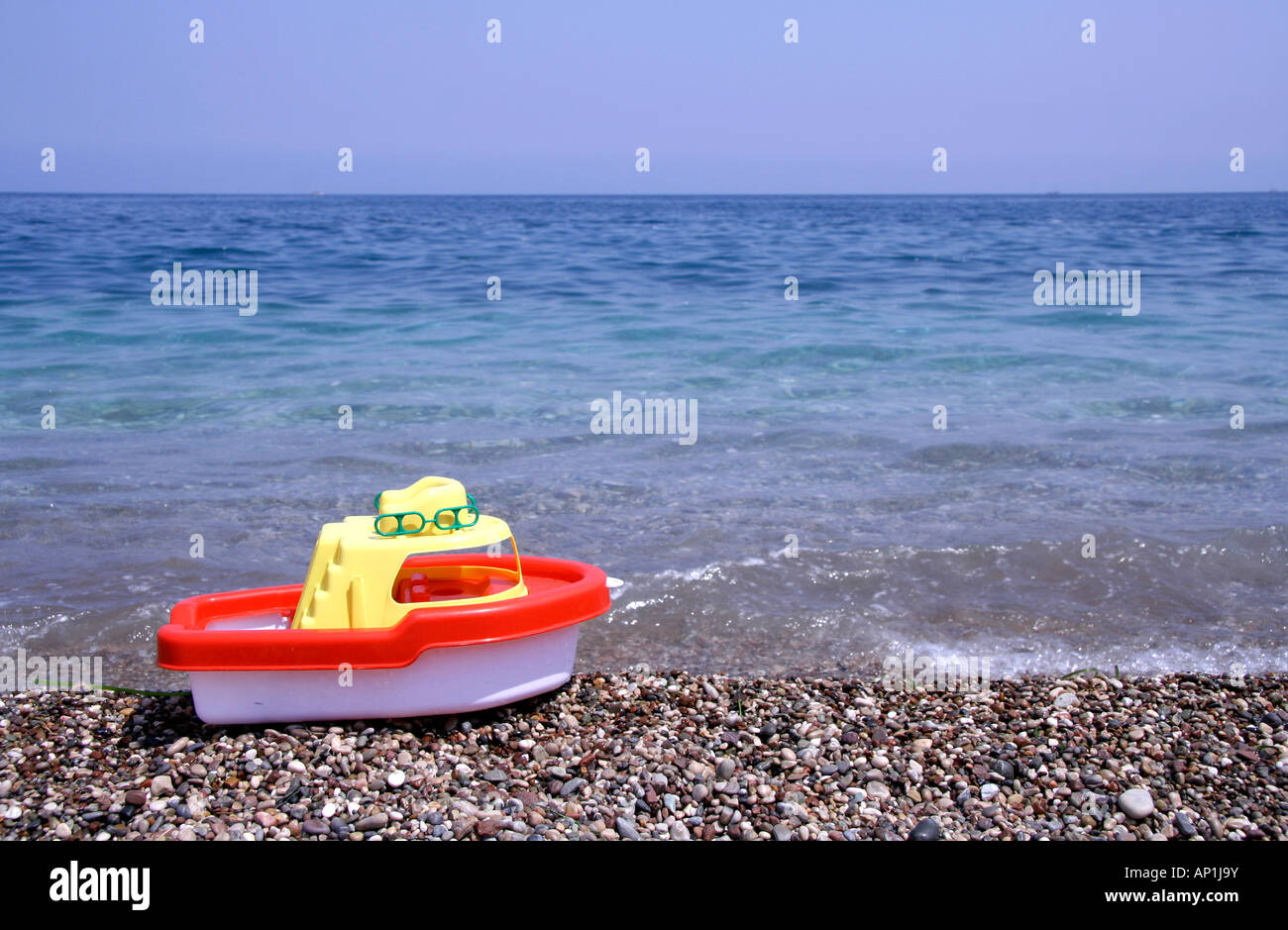 red and yellow toy plastic boat on beach Stock Photo - Alamy