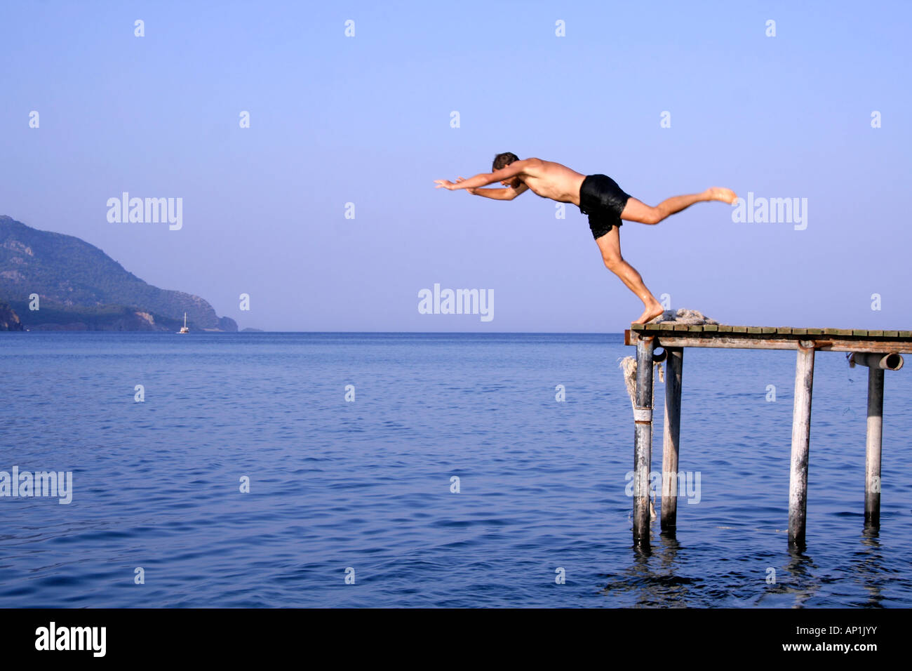 man jump diving from pier into sea Stock Photo - Alamy