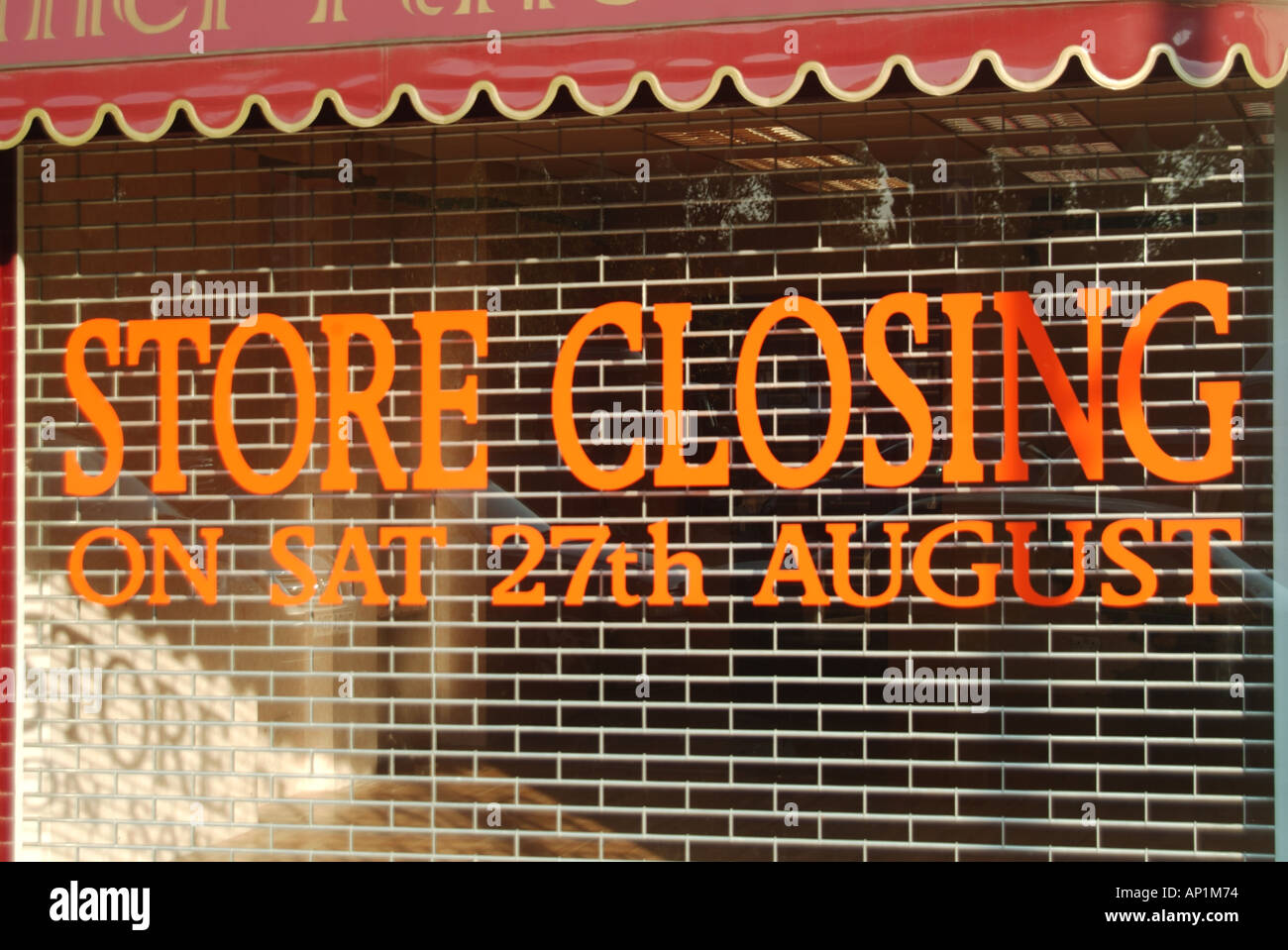 Store closing sign in shop window with security grill Essex England UK ...