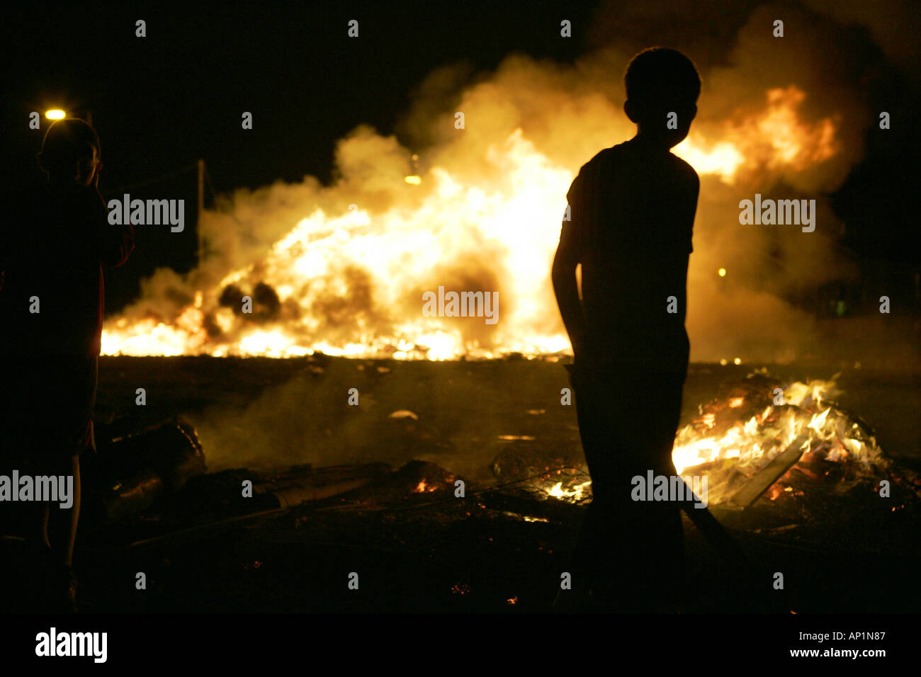 young boy walks past 11th night bonfire in Monkstown Stock Photo - Alamy