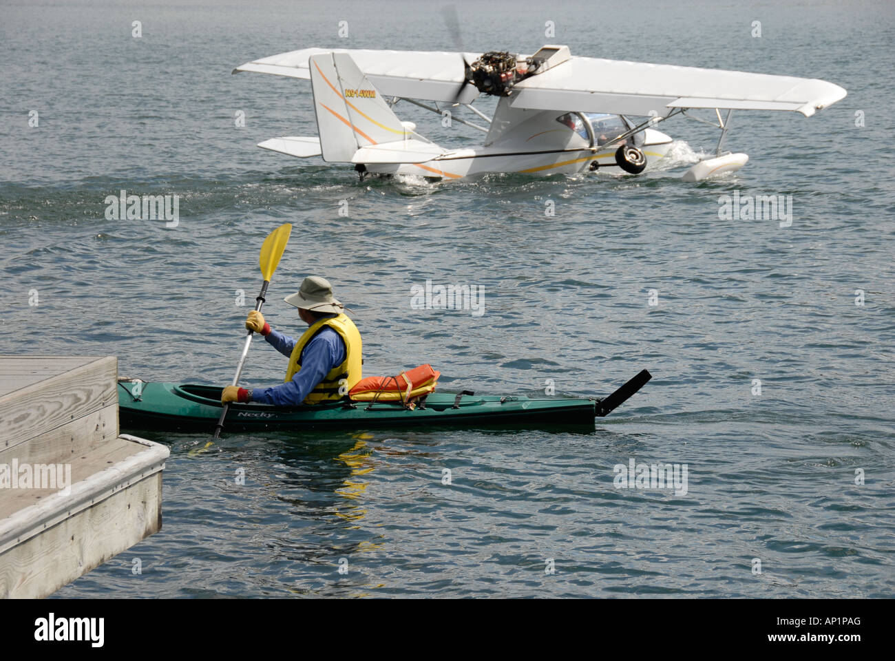 Sportsman in kayak on Lake Keuka, NY USA, with amphibian plane taking ...