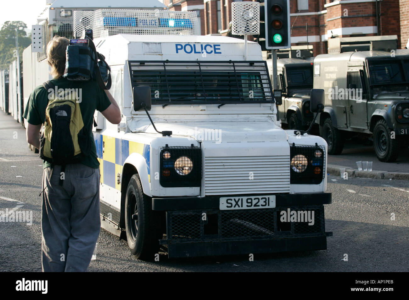 TV cameraman filming PSNI land rover on crumlin road at ardoyne shops ...