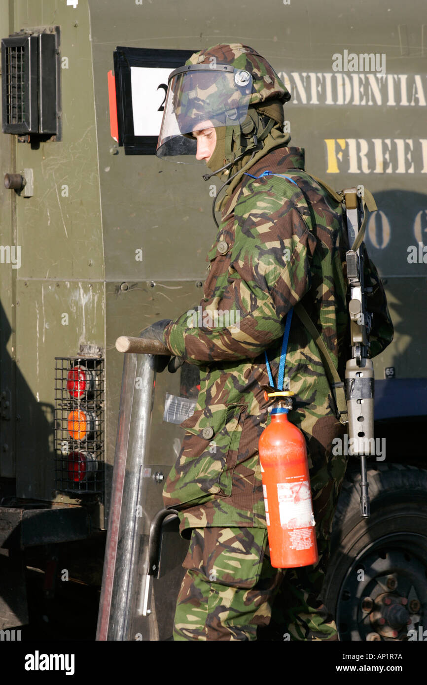 British Army soldier in riot gear with fire extinguisher in front of ...