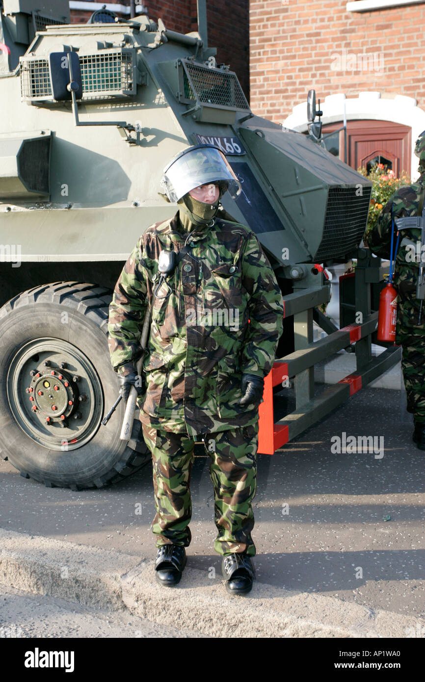 British army soldier in riot gear with Saxon armoured personnel carrier ...
