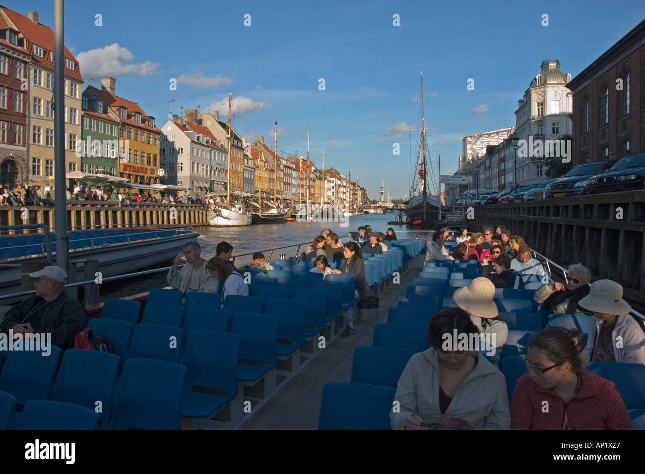 Boats and dock along Nyhavn Canal with tour boat in foreground ...