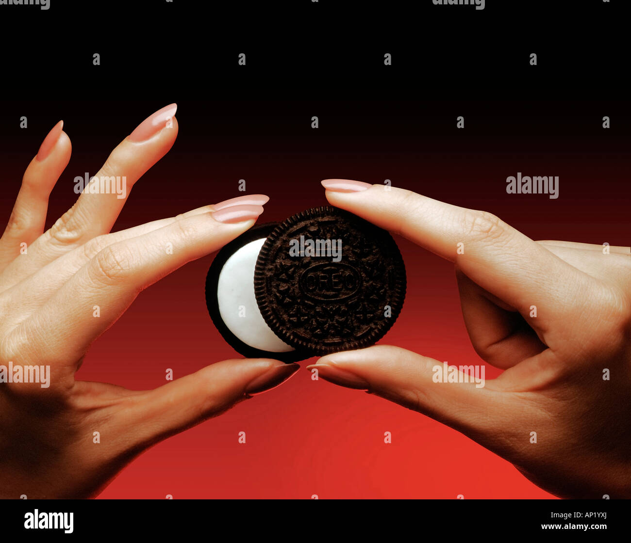 Two hands opening an Oreo Stock Photo - Alamy