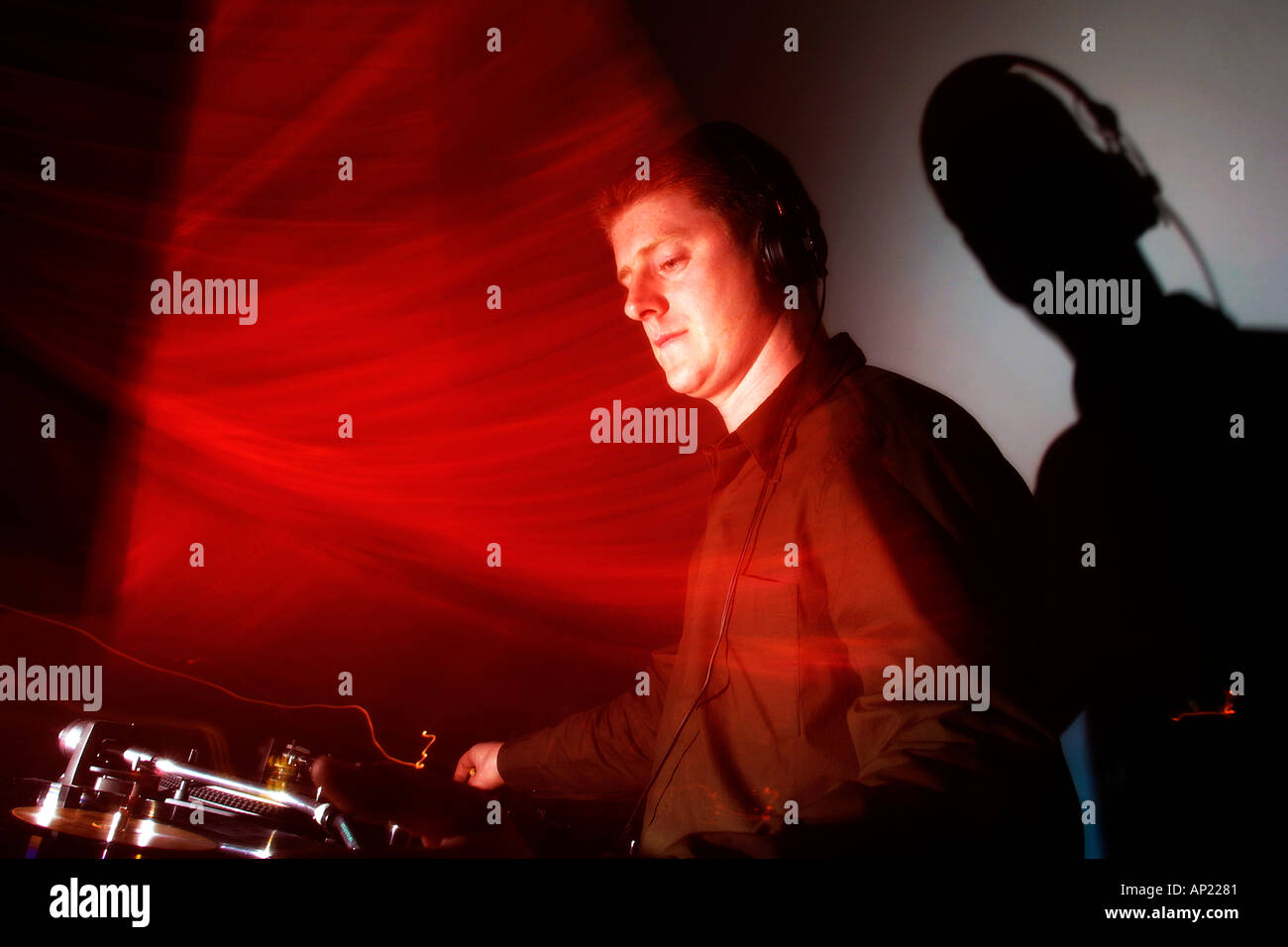 DJ at decks with shadow on wall Stock Photo - Alamy
