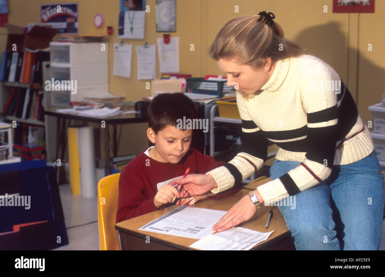 Teacher assisting an elementary school student Stock Photo - Alamy