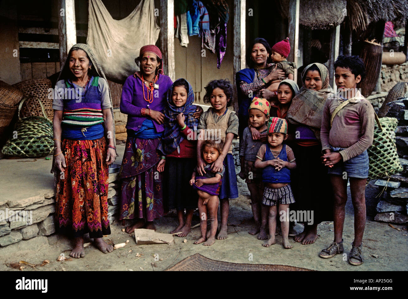 A smiling GURUNG FAMILY mostly female in the yard of their traditional ...