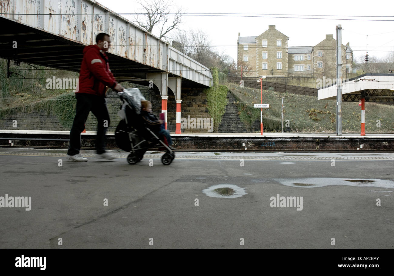 Man and pushchair moving along a platform Stock Photo - Alamy