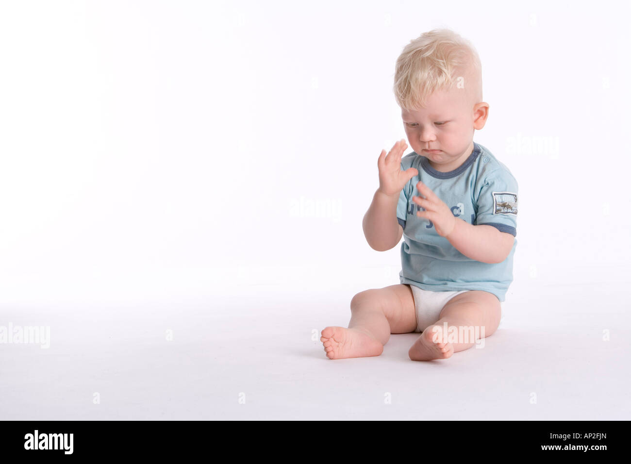 Little boy looking and playing with his own hands Stock Photo - Alamy