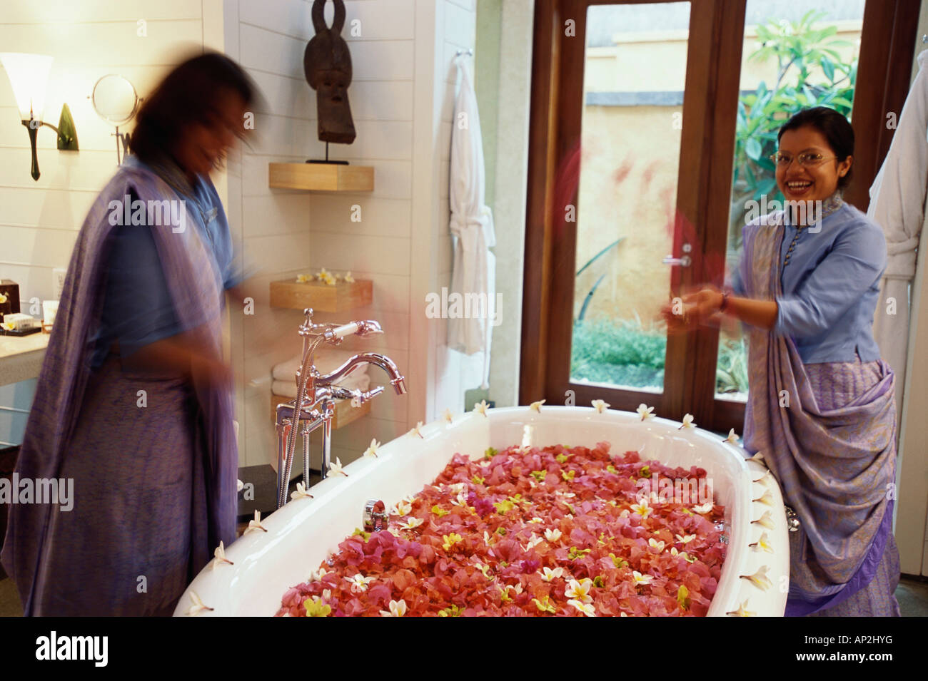 Women filling a bath with flower petals, Bathroom, Relaxation, Hotel ...