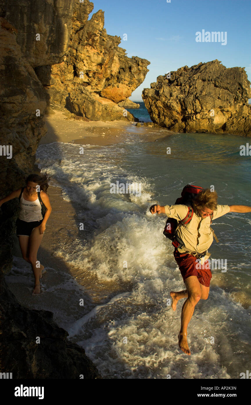 A couple jumping over the waves on a beach, Madagascar, Africa Stock ...