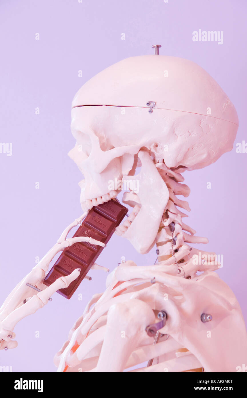 A human skeleton eating a bar of chocolate Stock Photo - Alamy