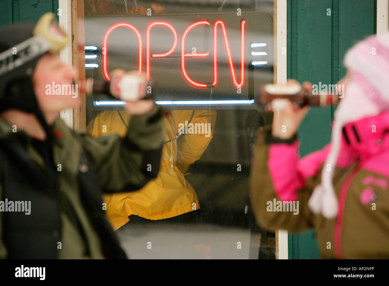 Two skiers drinking beer in front T-Bar pub, Castle Mountain ski resort ...