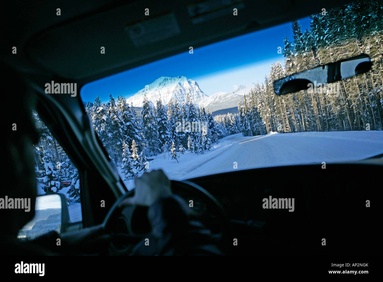 View through car windscreen towards snowy highway, near lake louise ...