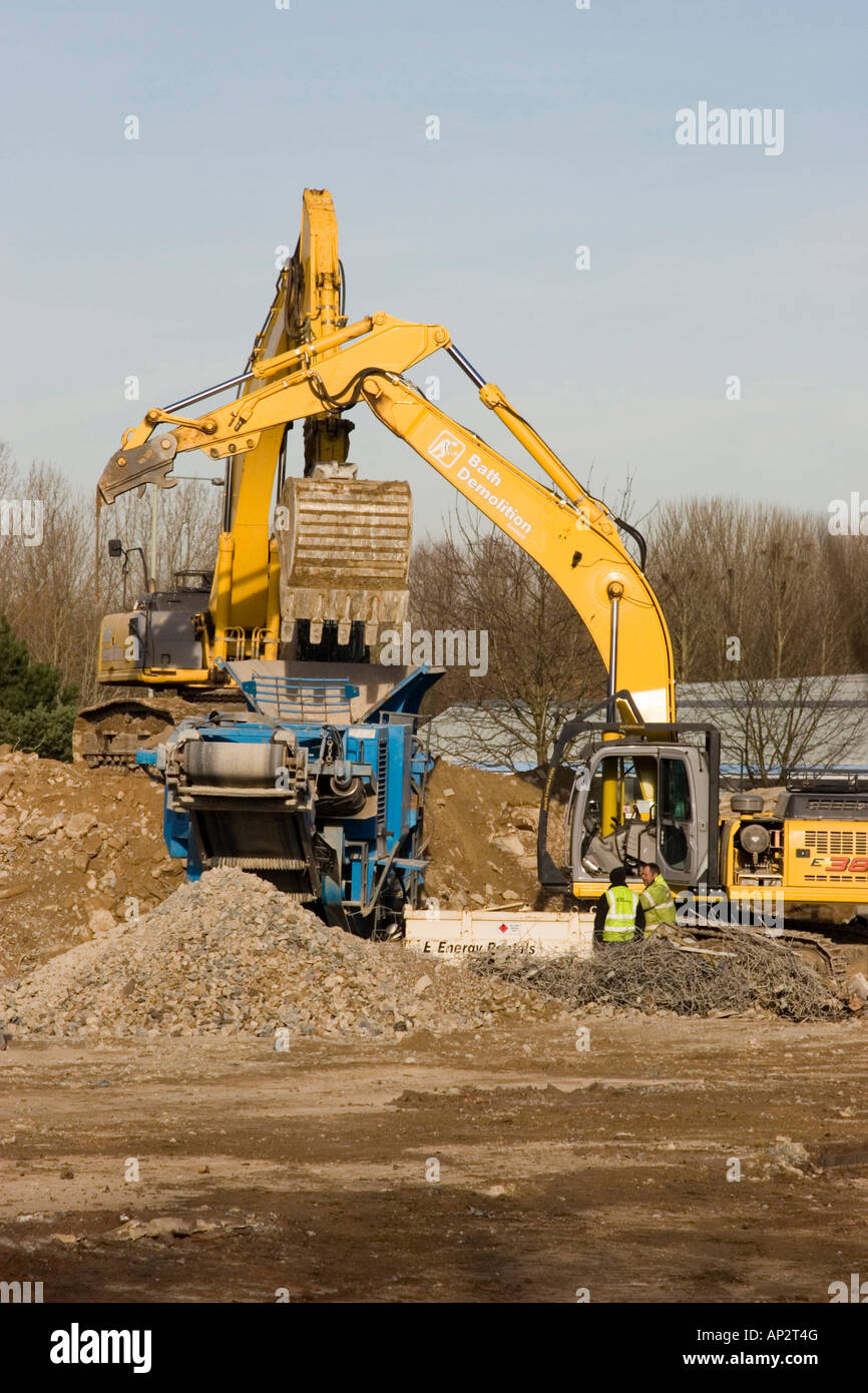 Heavy plant machines breaking up the concrete base of a brownfield ...