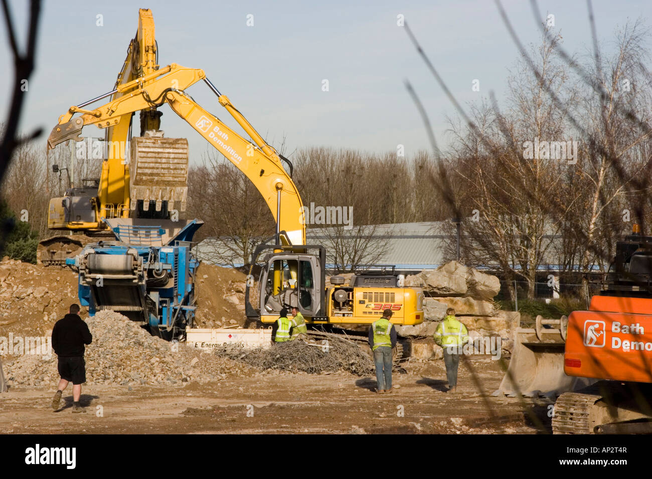 Heavy plant machines breaking up the concrete base of a brownfield ...