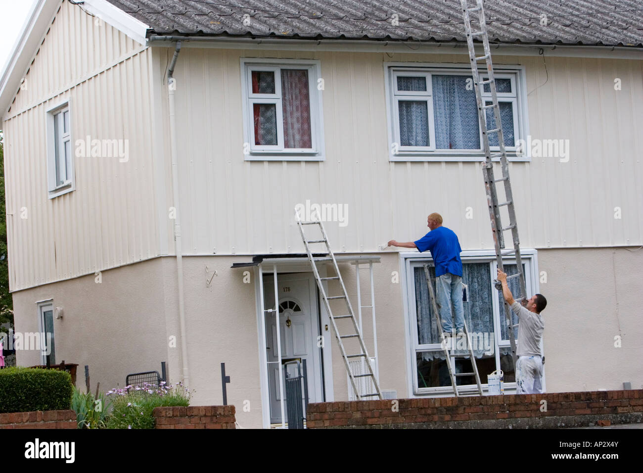 Council workmen painting prefabricated council house Stock Photo - Alamy
