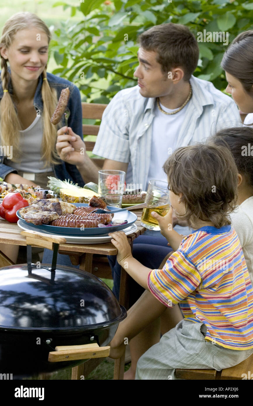 family having barbecue Stock Photo - Alamy