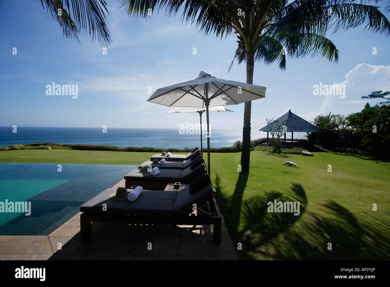 Sun loungers at the edge of the swimming pool, near Uluwatu, Bali ...