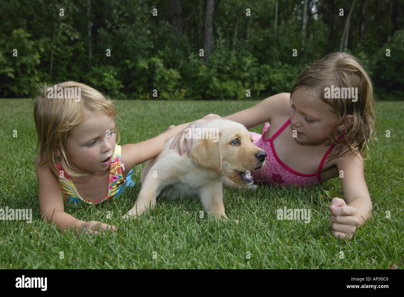 Two young girls with puppy Stock Photo - Alamy