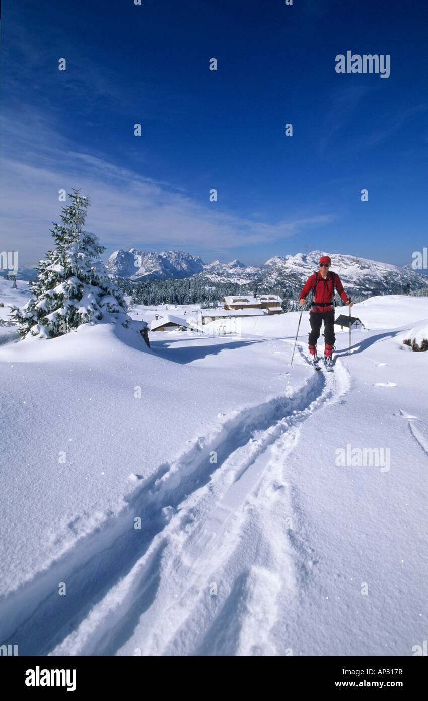 Backcountry skiier in front of deeply snow-covered lodge Straubinger ...