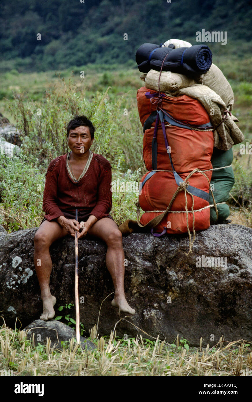 NEPALI PORTER rests from carrying a HUGE LOAD of two duffle bags in the ...