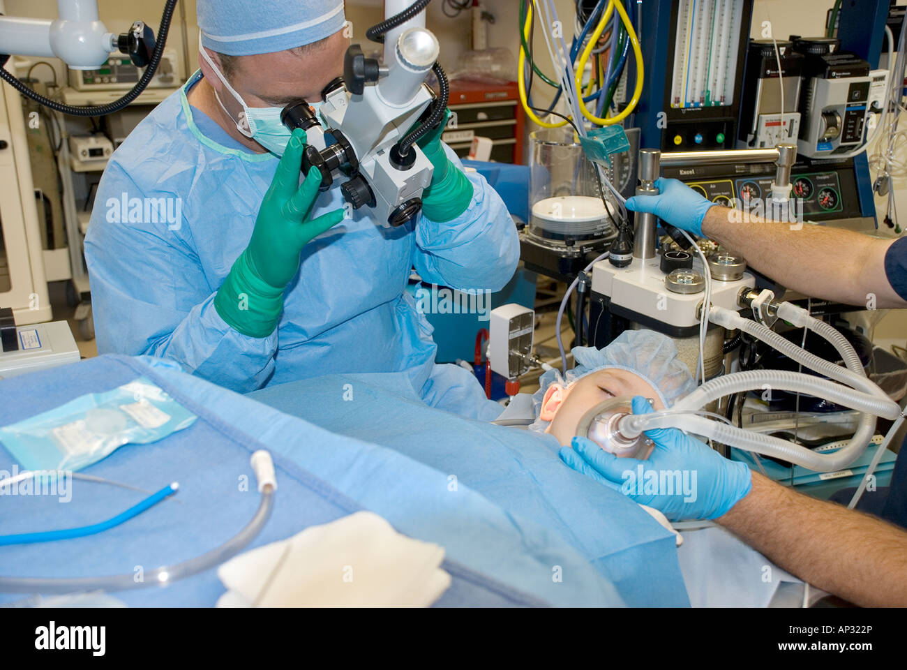 Surgical team performing ear surgery on young boy in hospital operating ...
