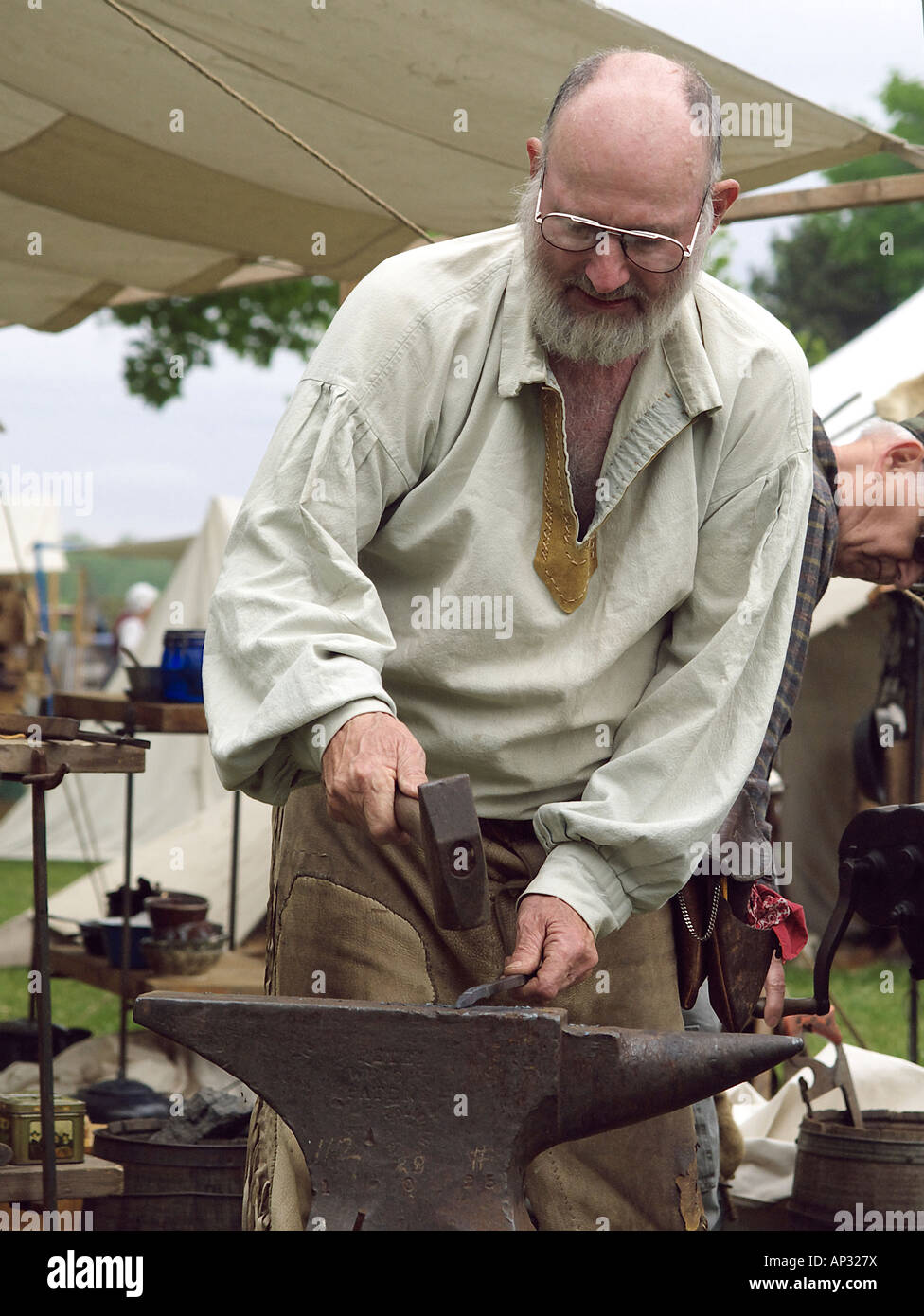 Man at a festival works metal with traditional blacksmith techniques ...