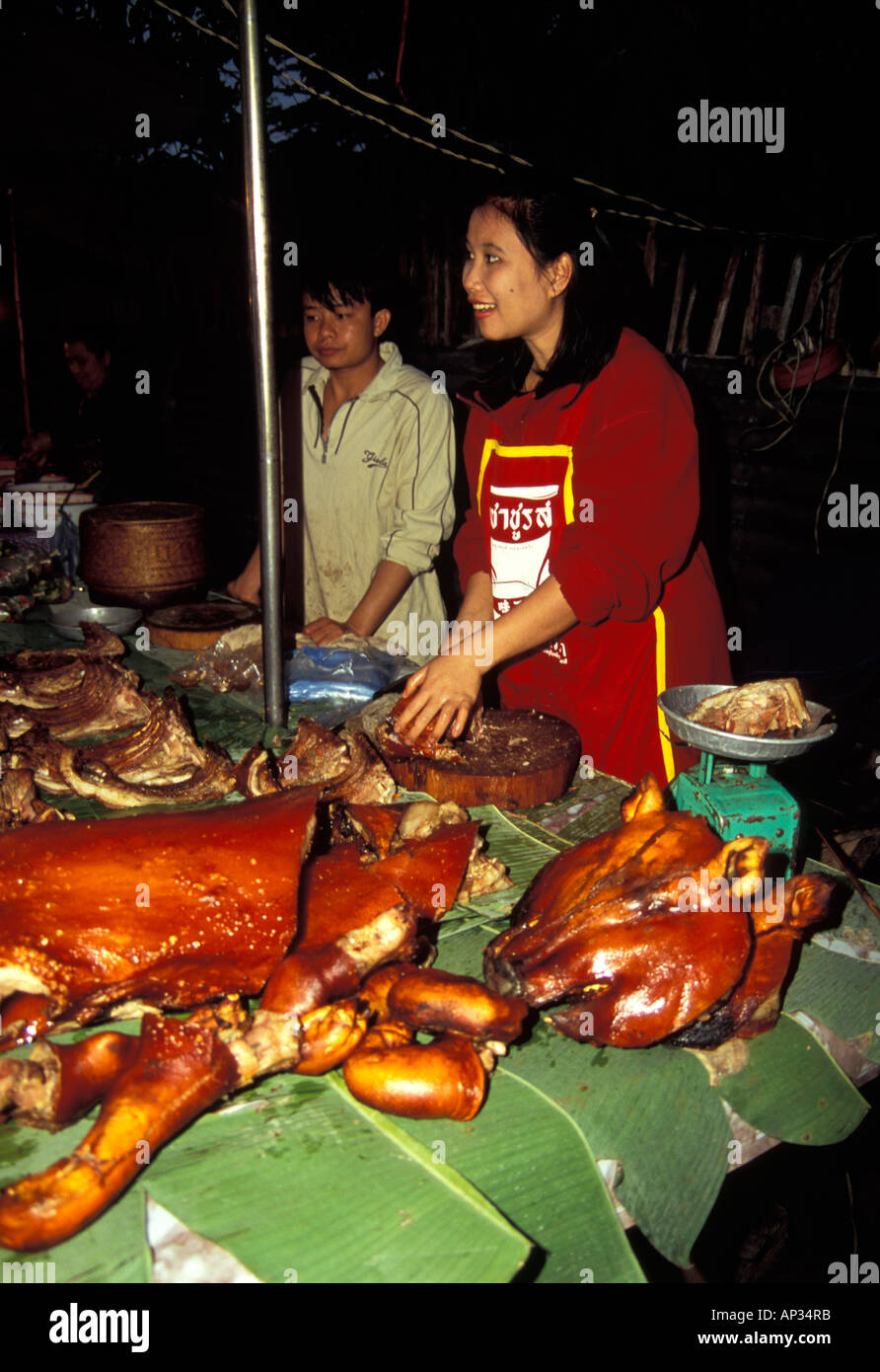 Butcher chopping up pig and pig's head for sale at market, Luang ...