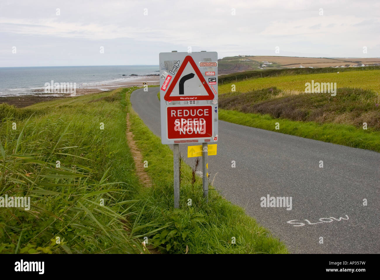 Road sign warning of dangerous bend and Reduce speed now Stock Photo ...