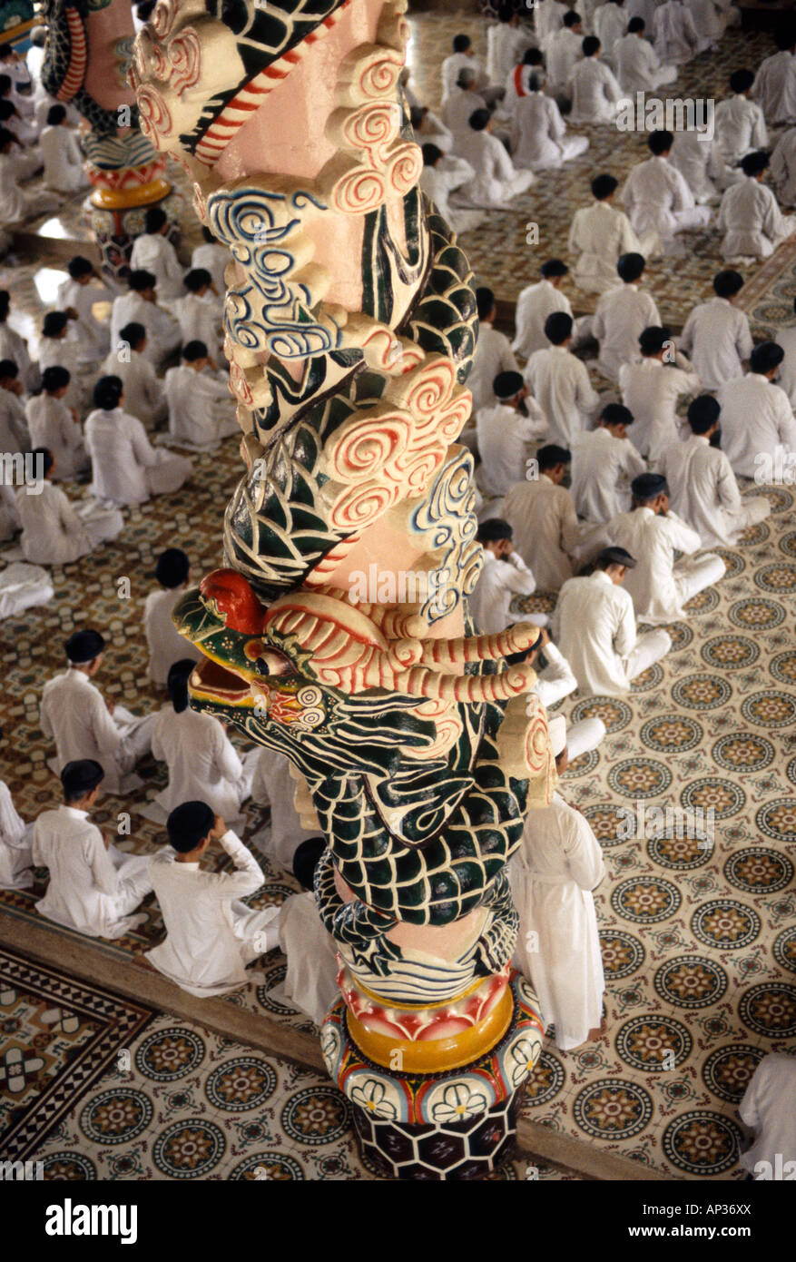 Caodaist disciples, sitting during ceremony by colorful columns, Cao ...