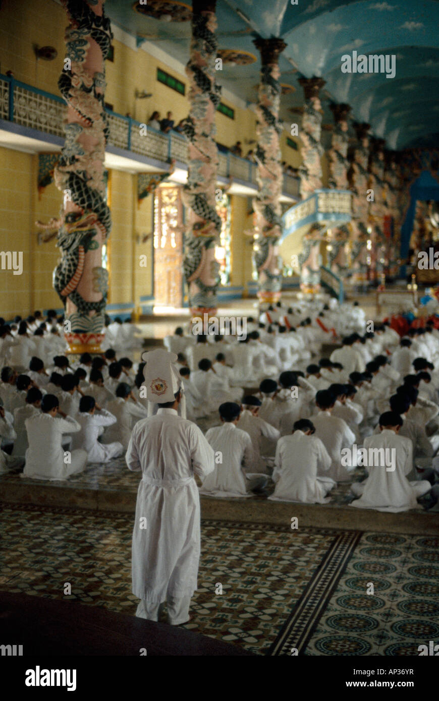 Caodaist disciples, sitting during ceremony by colorful columns, Cao ...